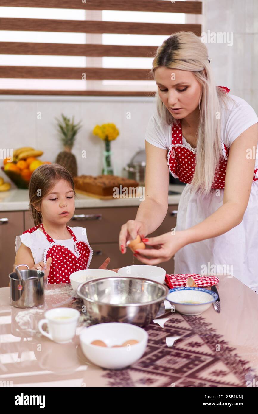 Little girl helping her mother cooking in the kitchen Stock Photo - Alamy