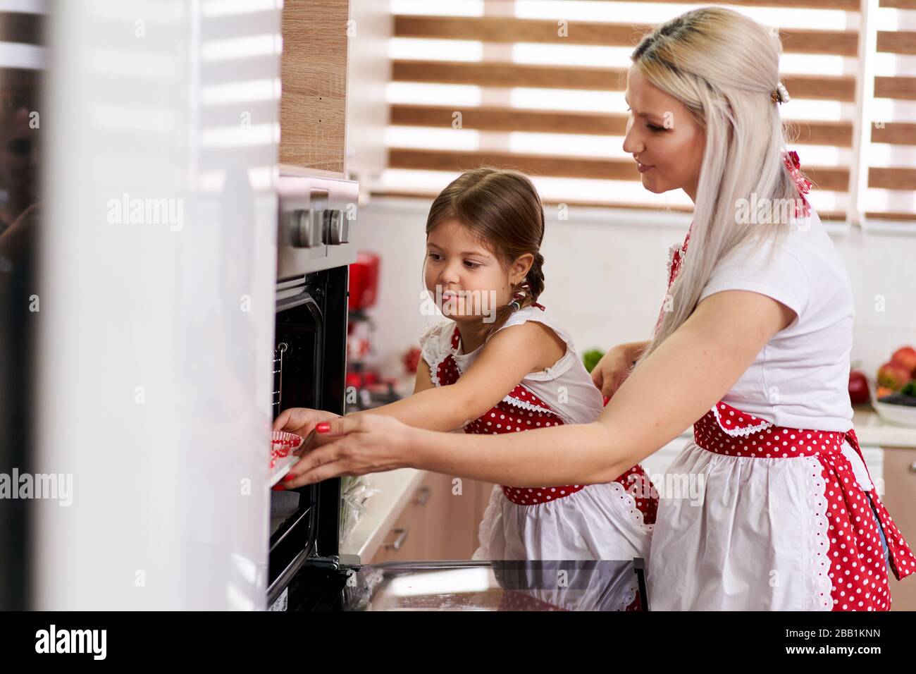 Little girl helping her mother cooking in the kitchen Stock Photo - Alamy