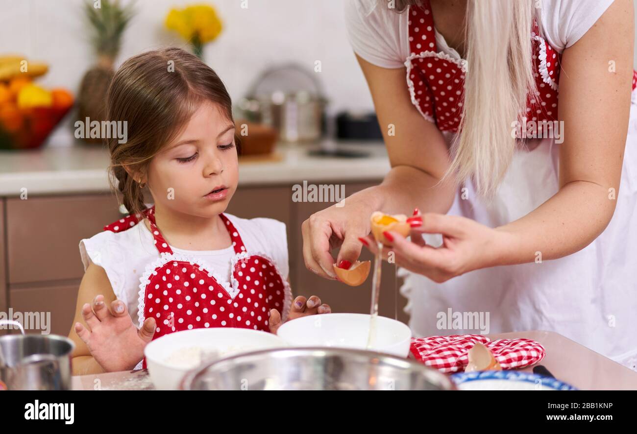 Little girl helping her mother cooking in the kitchen Stock Photo - Alamy