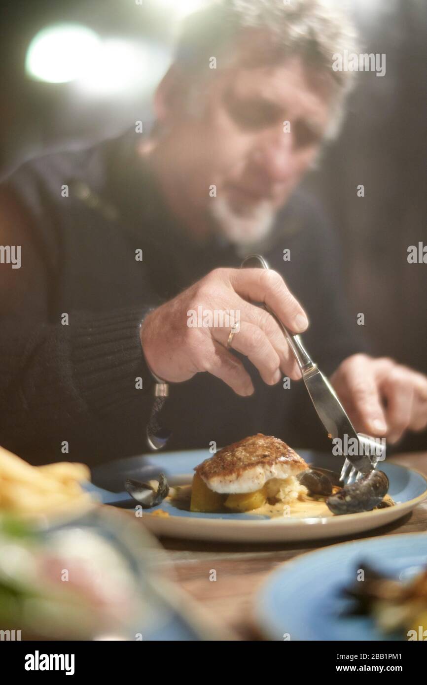 Friesian senior man eating fish for dinner Stock Photo - Alamy