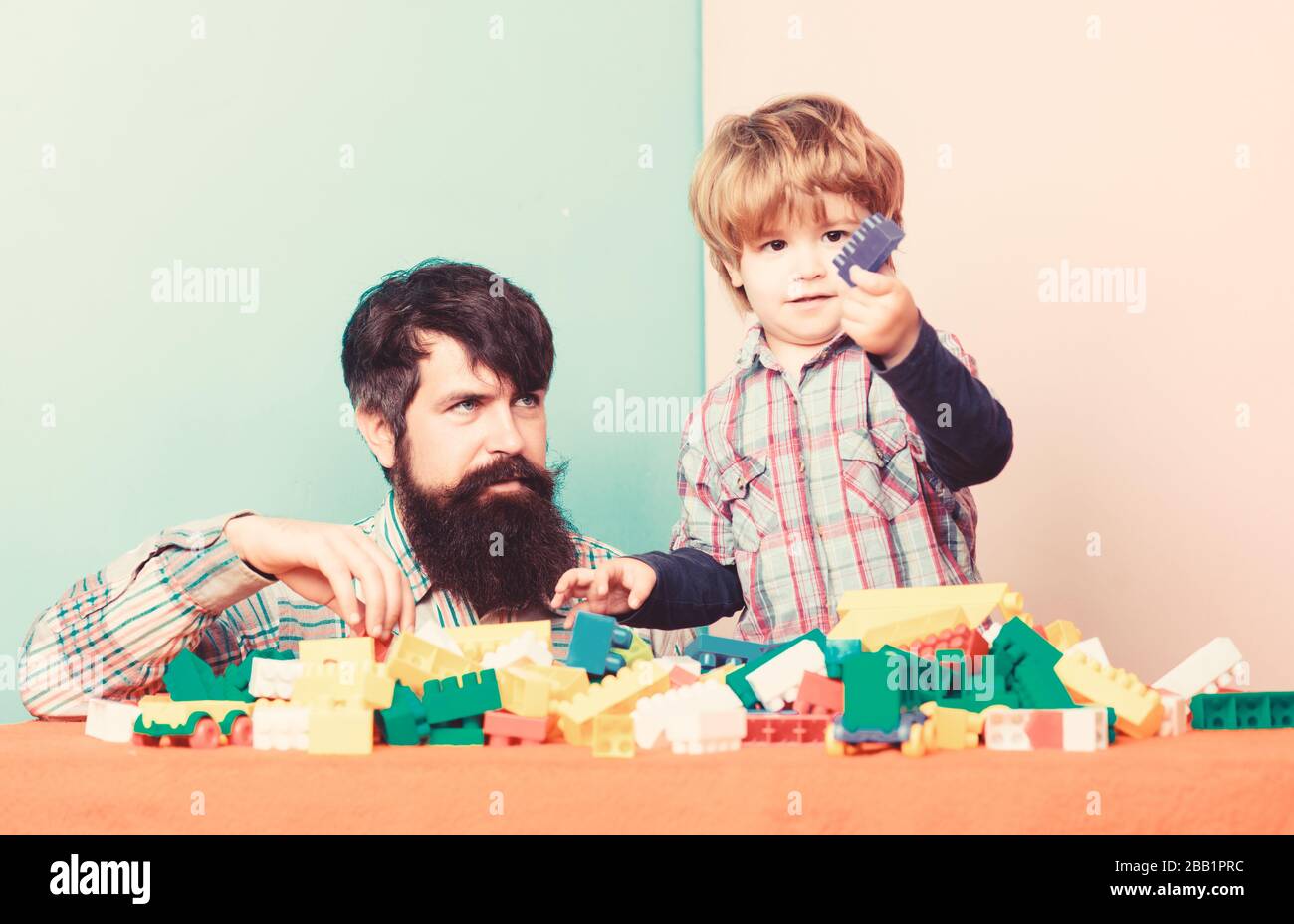 building home with constructor. little boy with bearded man dad playing ...