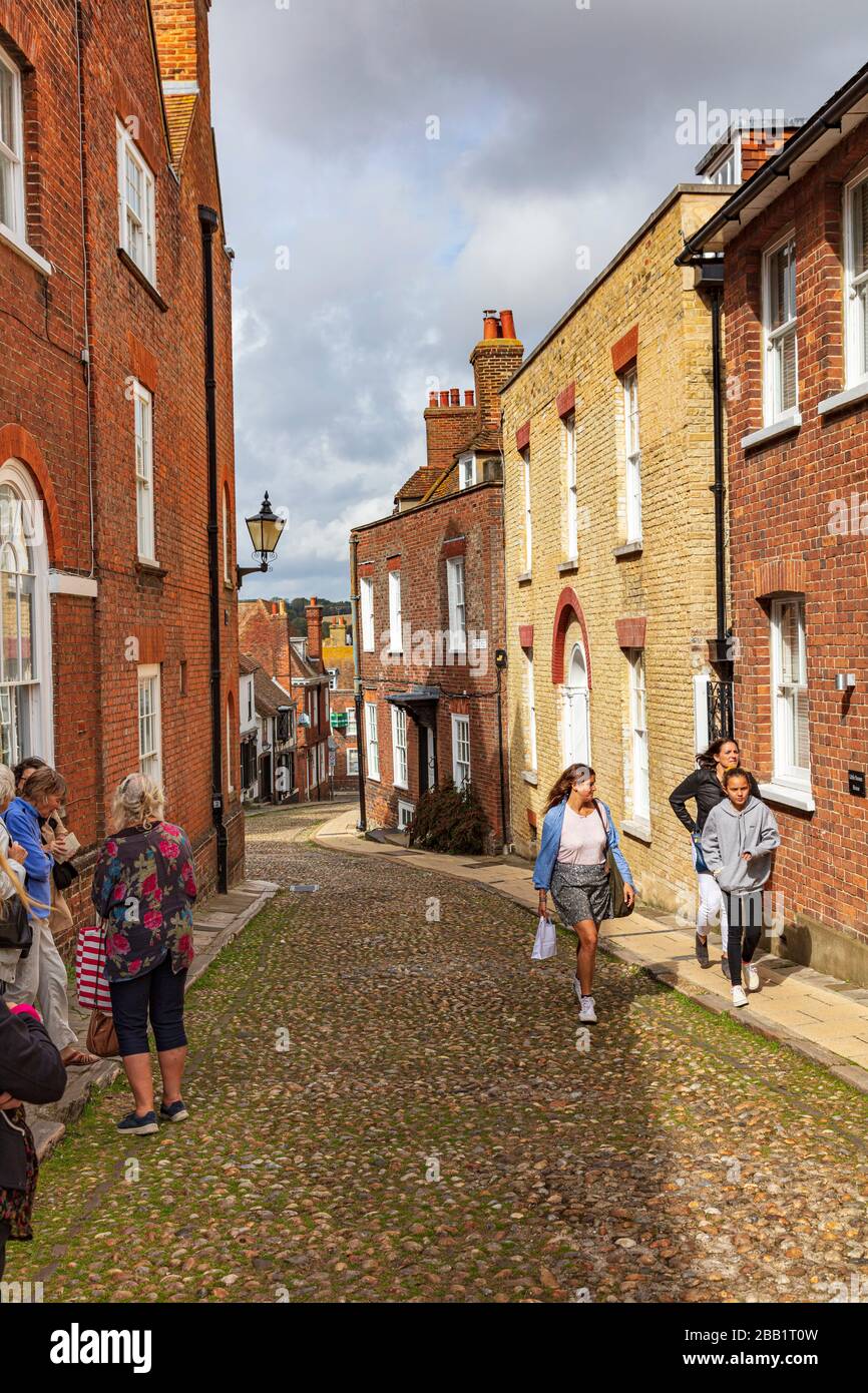 Visitors to Rye walk up West Street Rye, a cobbled road, and some wait ...
