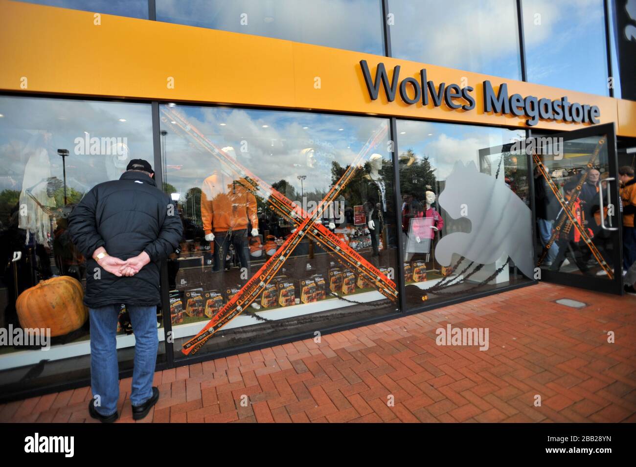 A Wolverhampton Wanderers fan peers through the window of the club shop ...