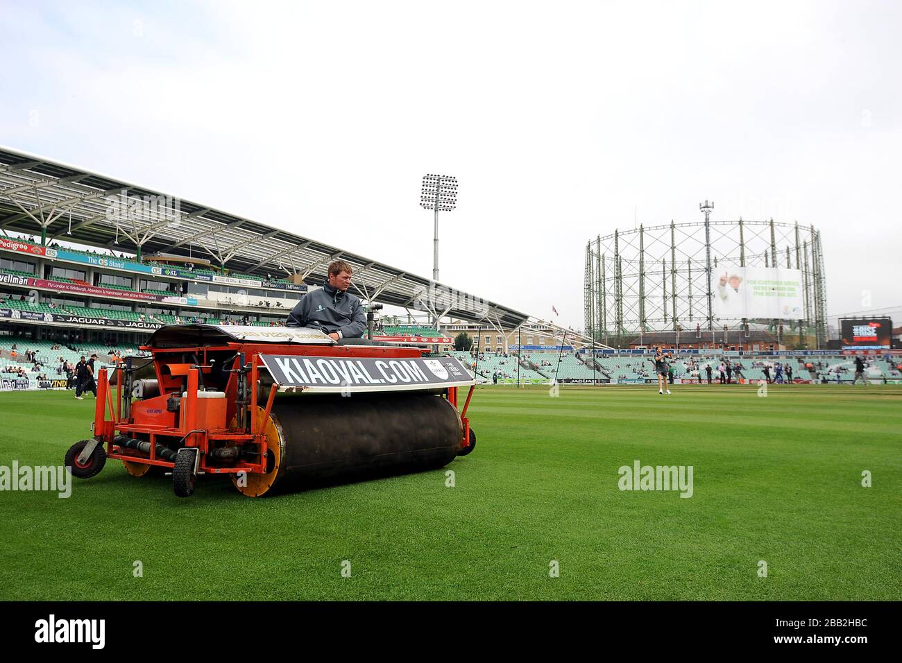 Ground staff mop up water from the outfield before play on day five of ...