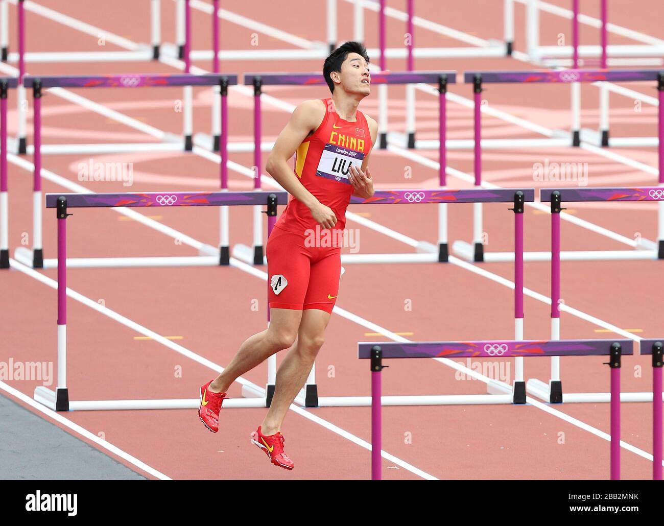 China's Liu Xiang hops down the track after hitting the first hurdle ...