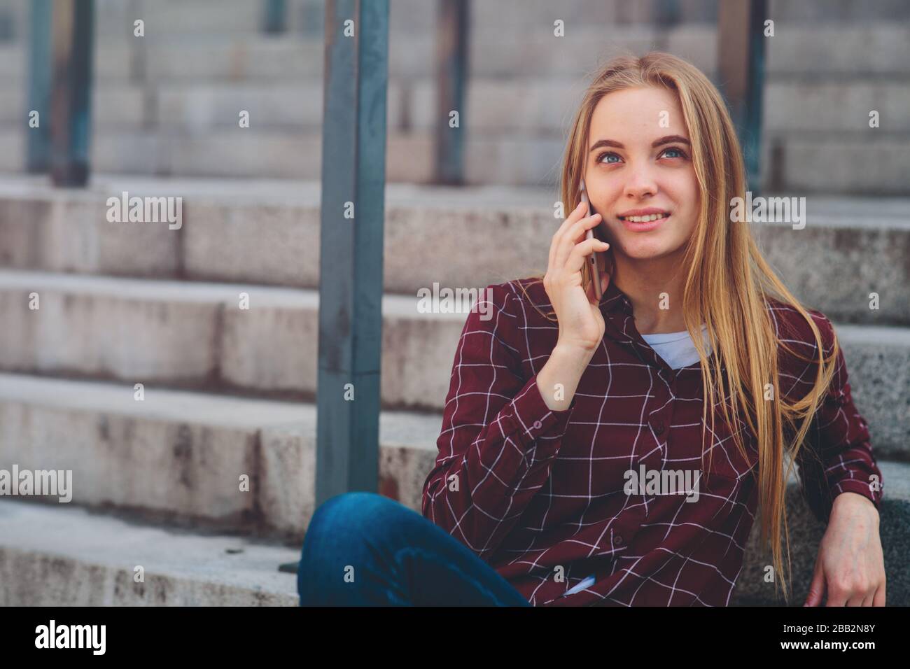 The girl is sitting on the steps and talking on the phone Stock Photo ...