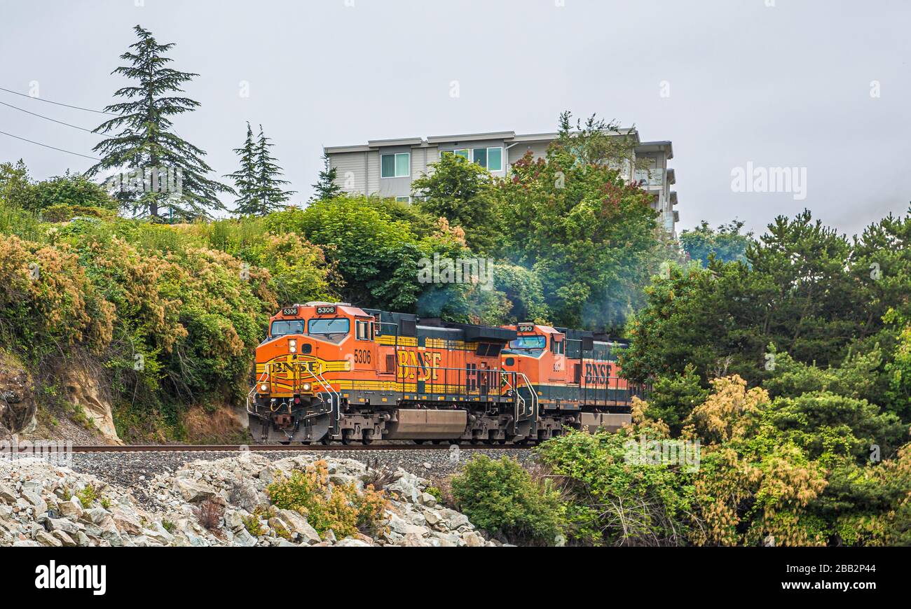 Orange Train Rolling Down Tracks Stock Photo - Alamy