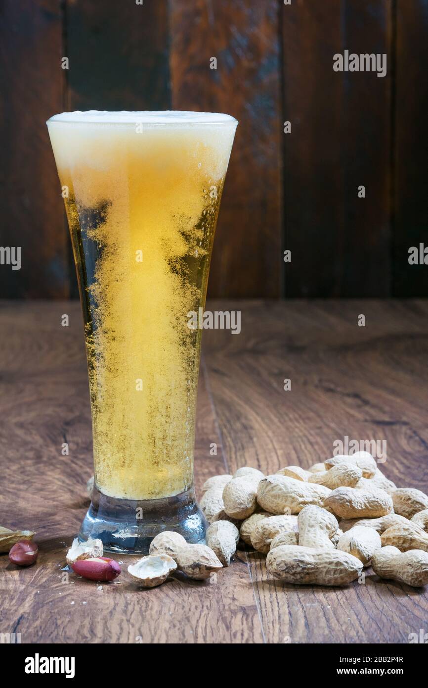 A glass of light beer with peanuts was photographed in the studio Stock ...