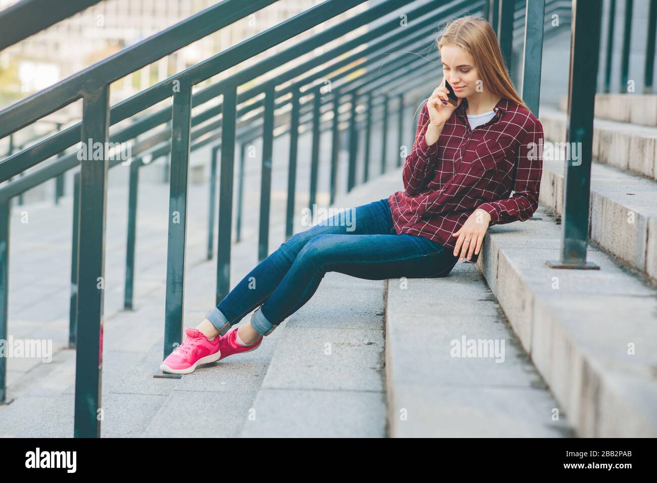 The girl is sitting on the steps and talking on the phone Stock Photo ...