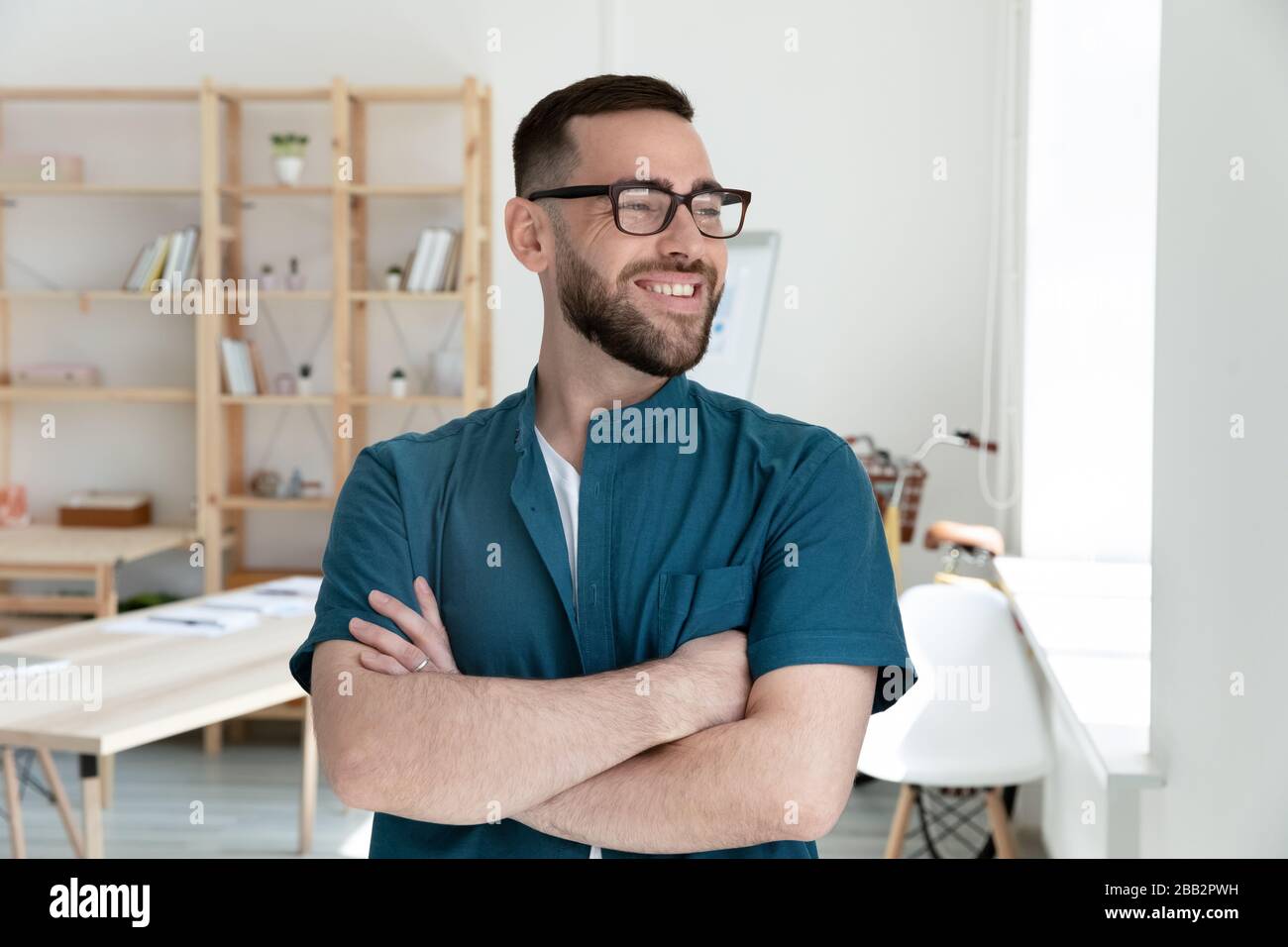 Smiling male employee look in distance dreaming Stock Photo - Alamy