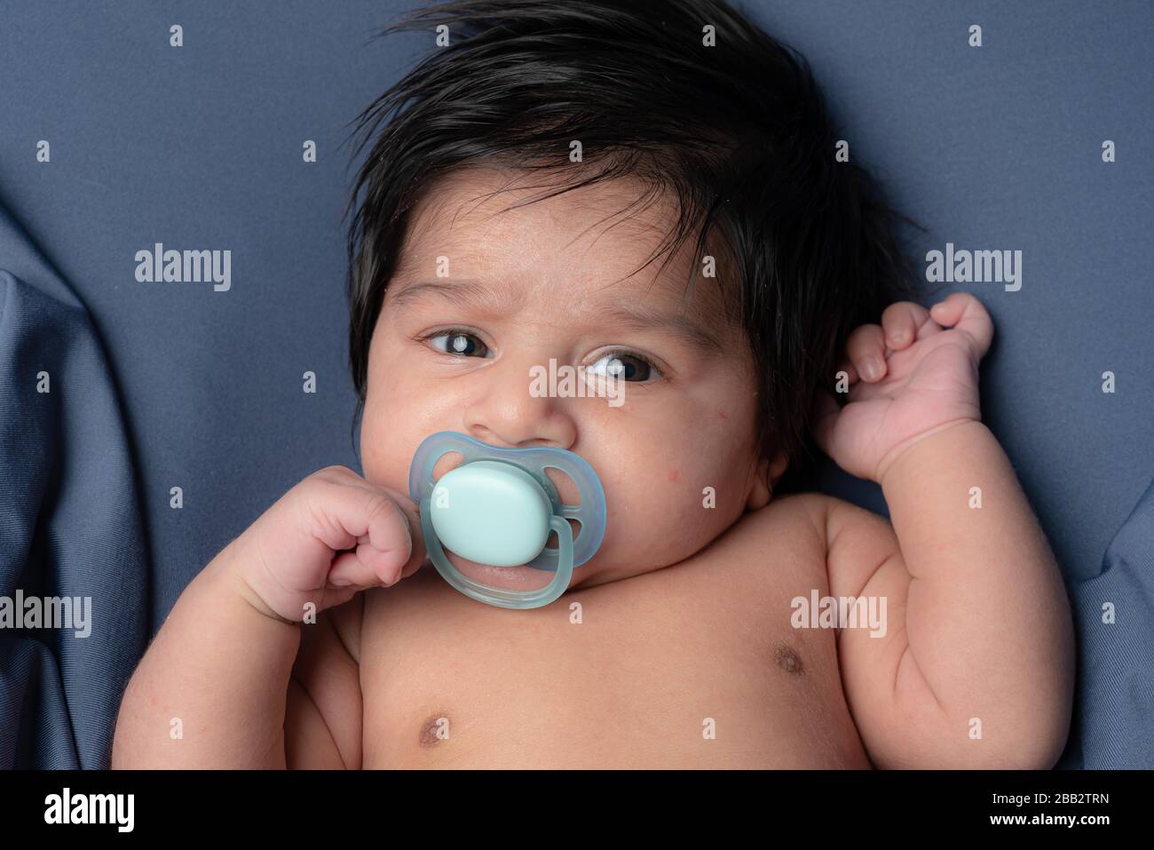 Close up of Little beautiful baby with a pacifier, Looking at camera ...