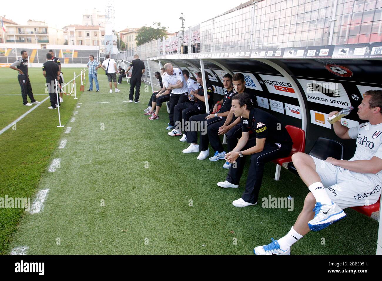 Fulham players and staff in the dugout at the Municipal du Ray, home of ...