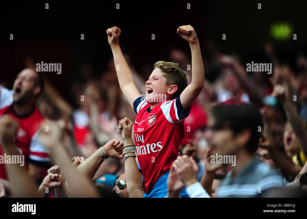 A young Arsenal fan celebrates in the stands Stock Photo - Alamy