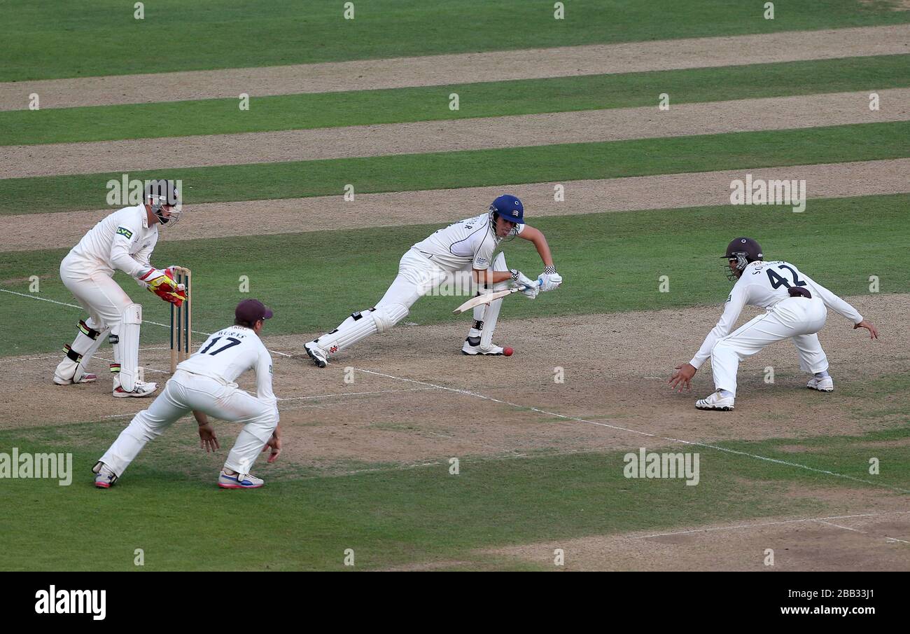 Middlesex's Neil Dexter hits out as Surrey's Steve Davies (left) looks ...