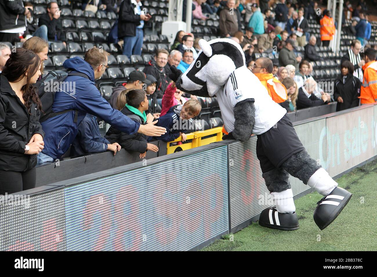 Fulham mascot Billy the Badger greets fans at the side of the pitch ...