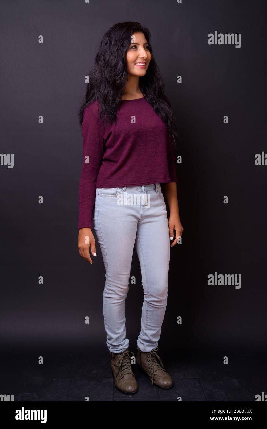 Full body shot of happy young beautiful Indian woman thinking Stock ...