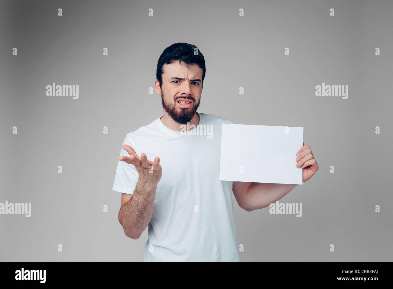 Young man isolated over background. Guy hesitate on camera. Emotional ...