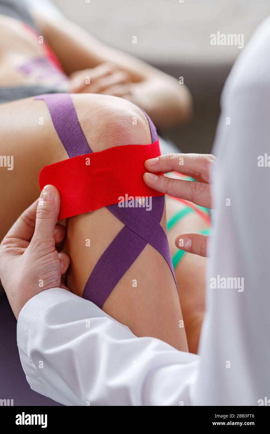 Kinesiology taping.Physical therapist applying kinesiology tape Stock Photo - Alamy