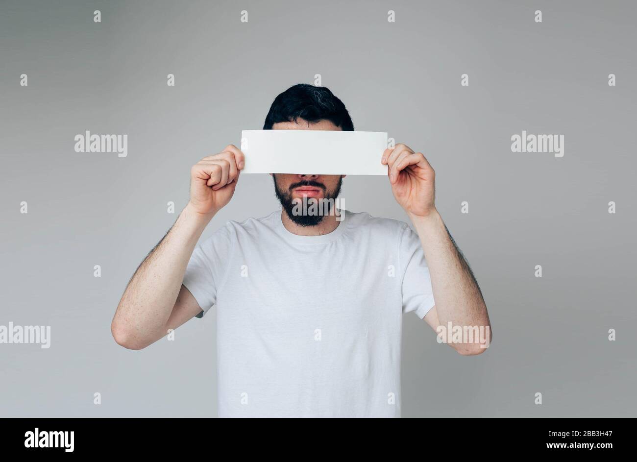 Young man isolated over background. Calm peaceful guy cover eyes with ...