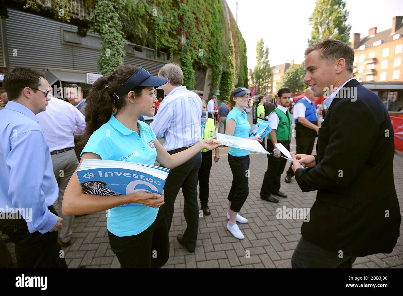 A member of the Investec team hands out Cricket United 4s and 6s cards ...