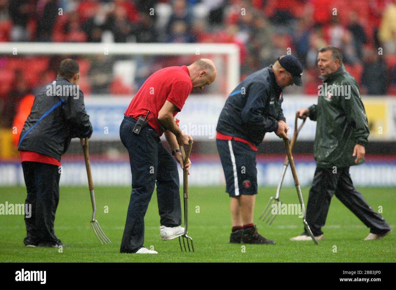 Ground staff tend to the wet surface after the Referee suspended the ...