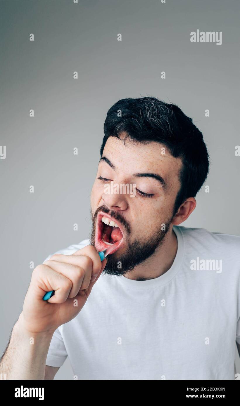 Young man isolated over background. Hardworking serious guy cleaning ...