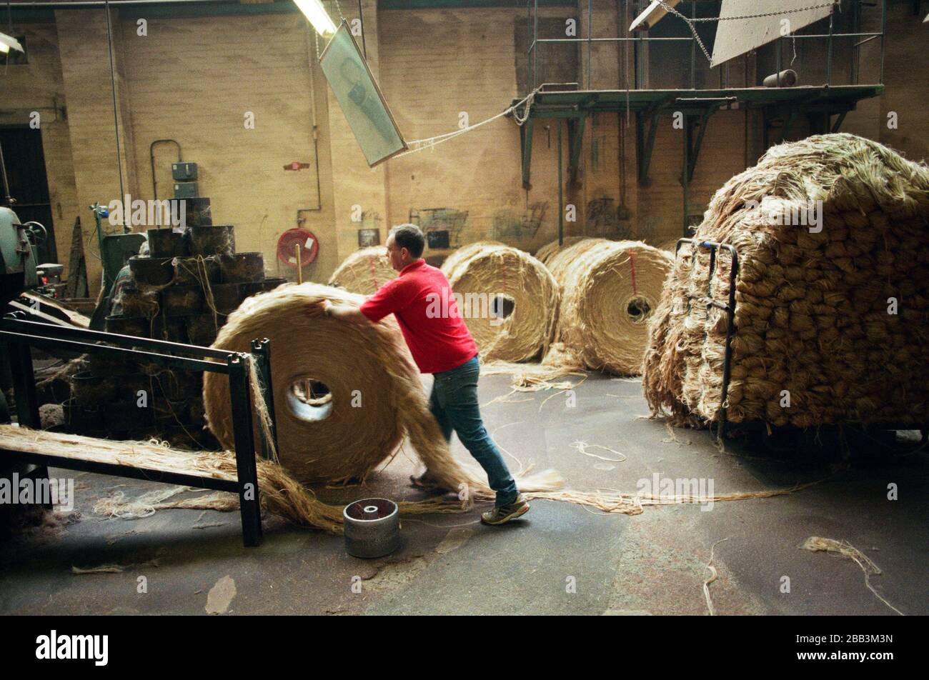 A worker rolling a circular bale of jute at Tay Spinners mill in Dundee ...