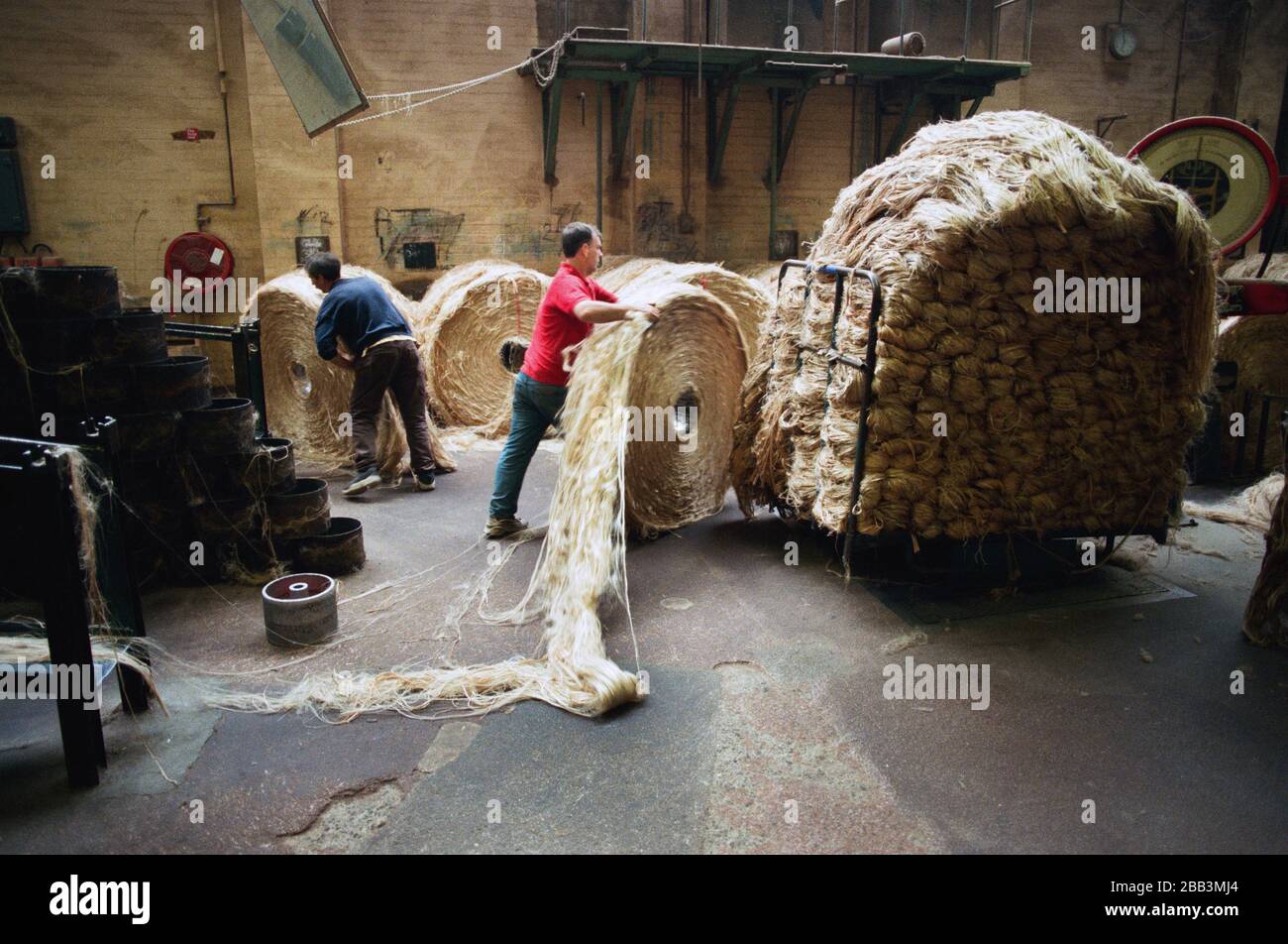 A worker rolling a circular bale of jute at Tay Spinners mill in Dundee ...