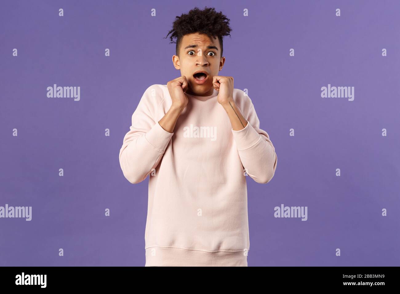 Portrait of scared hispanic guy screaming from fright, hold hands near ...