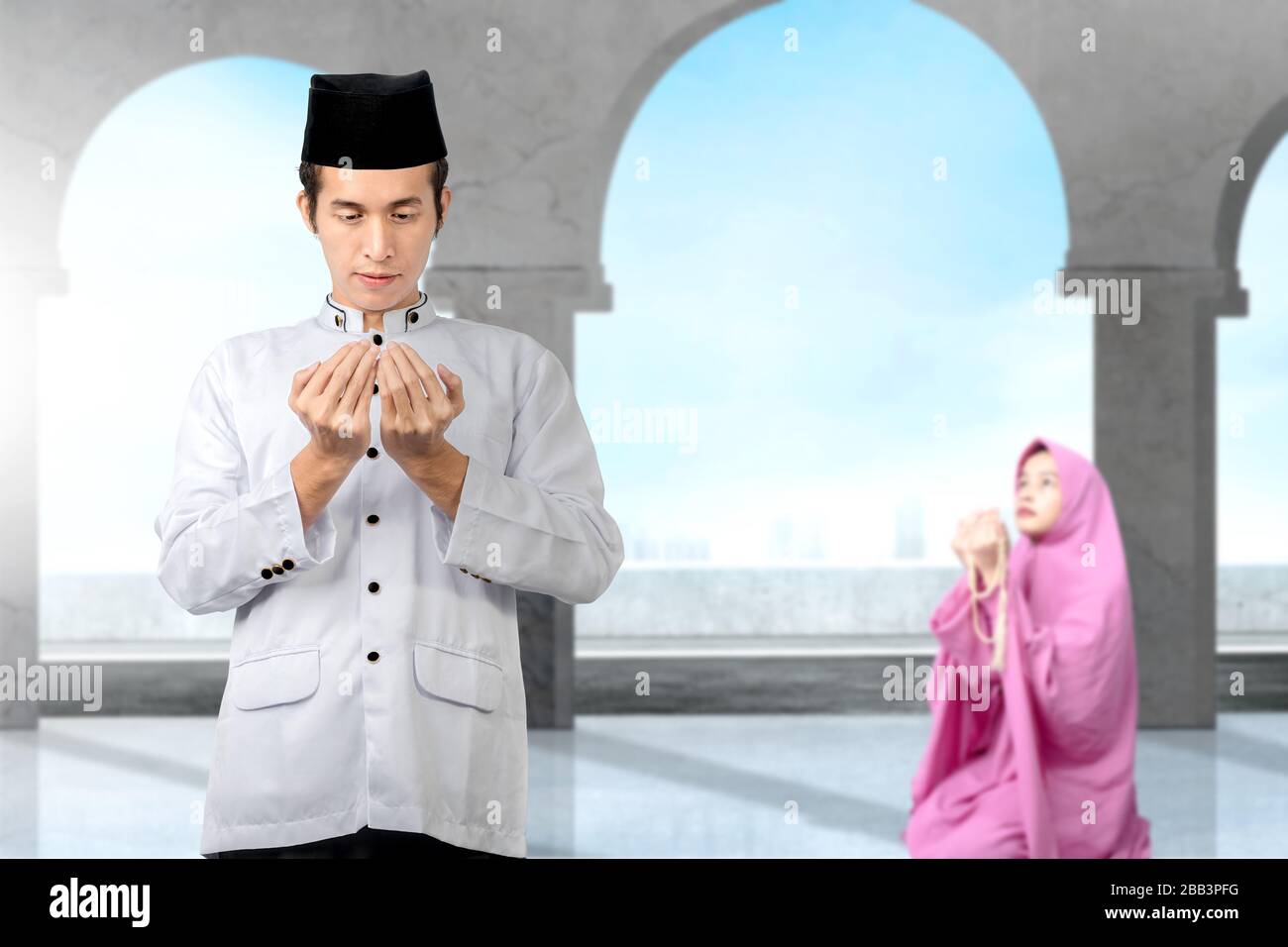 Asian Muslim couple praying together inside the mosque Stock Photo - Alamy