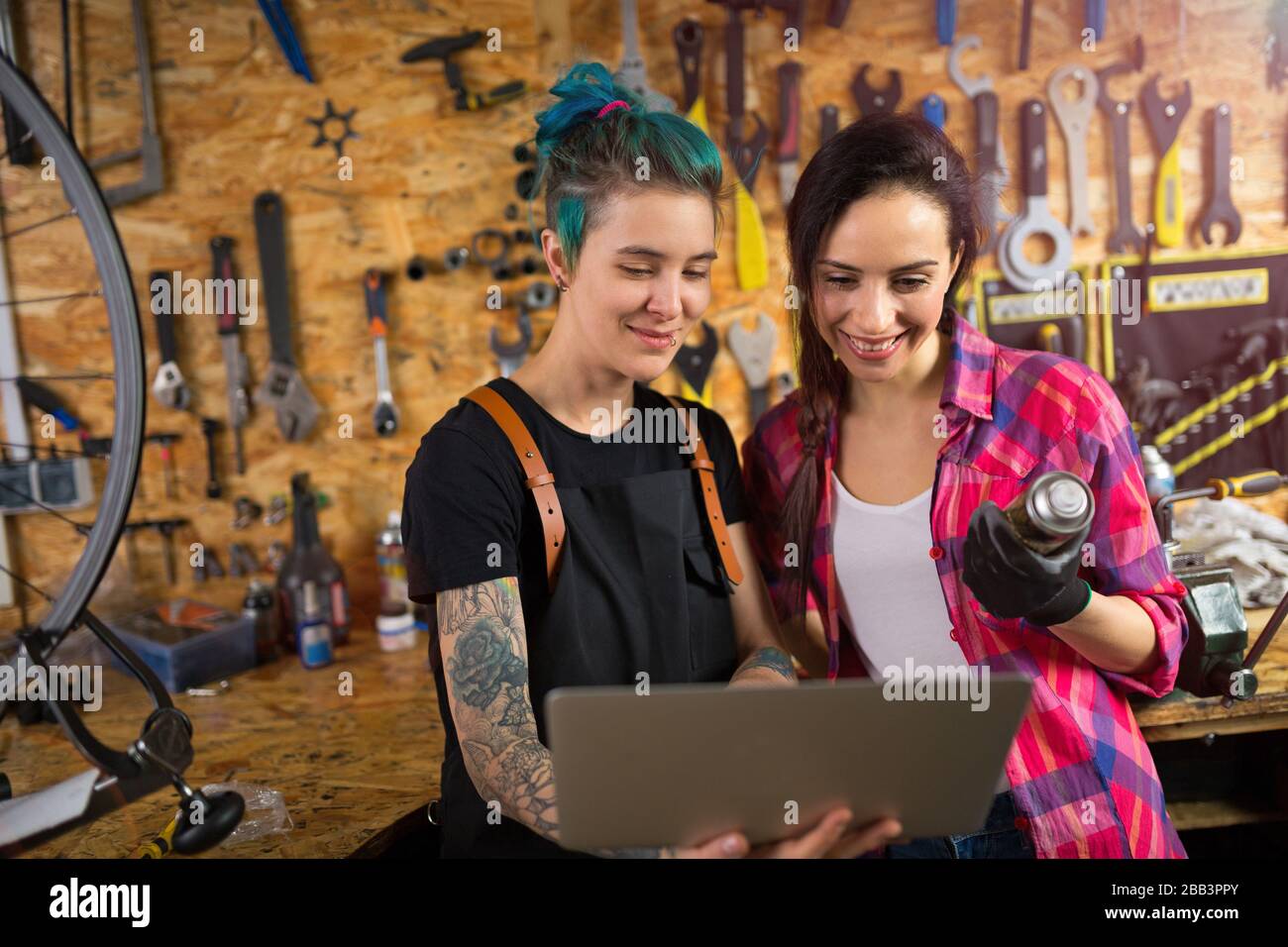 Two young women working in a bicycle repair shop Stock Photo - Alamy