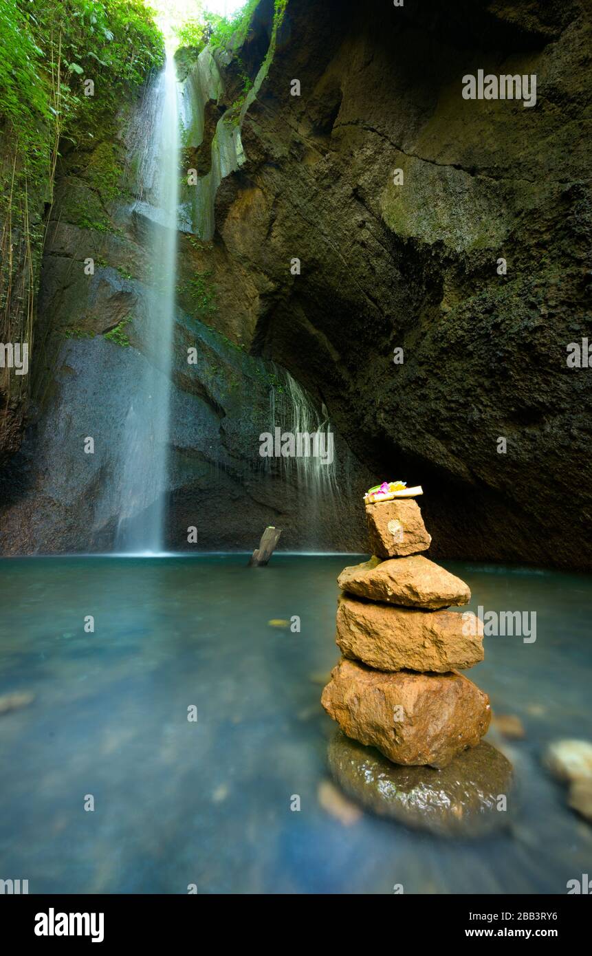 Balinese offerings placed on balanced rock pile in Pengempu waterfall ...