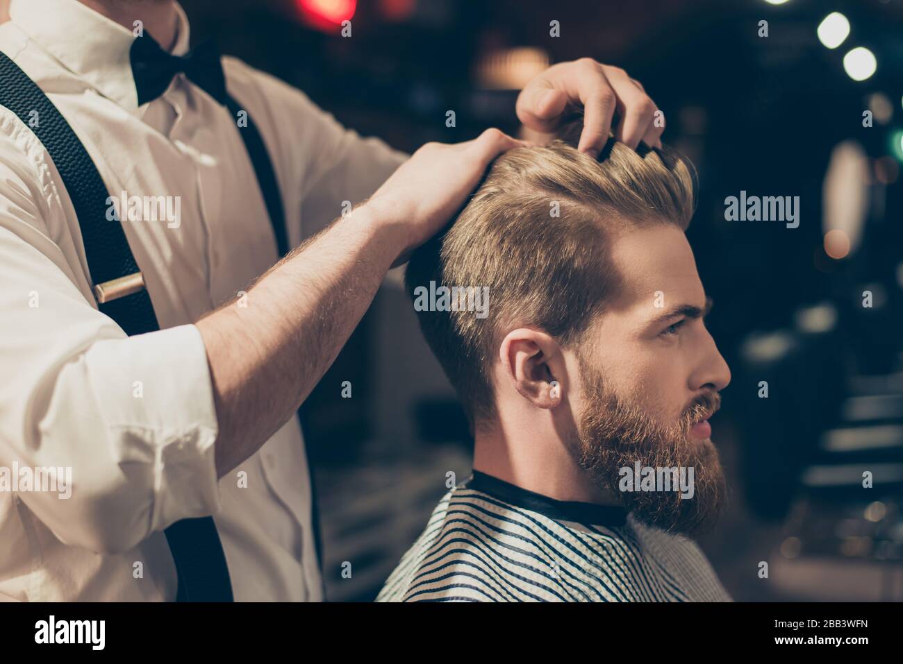 Profile view of handsome classy dressed barber shop stylist, who is ...