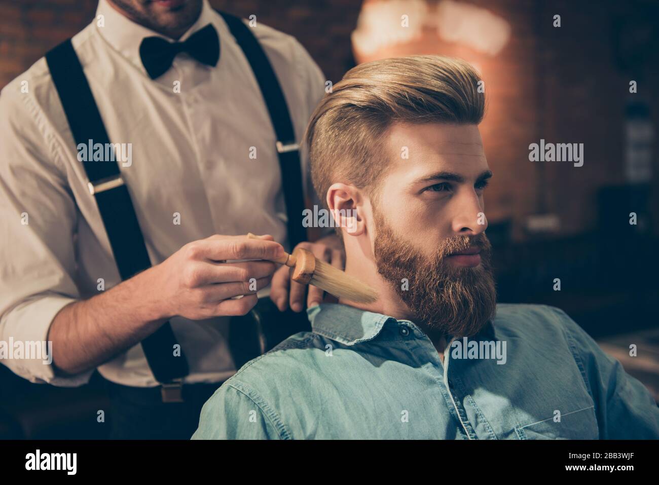 Classy dressed barber shop hairdresser is cleaning client`s neck with a ...