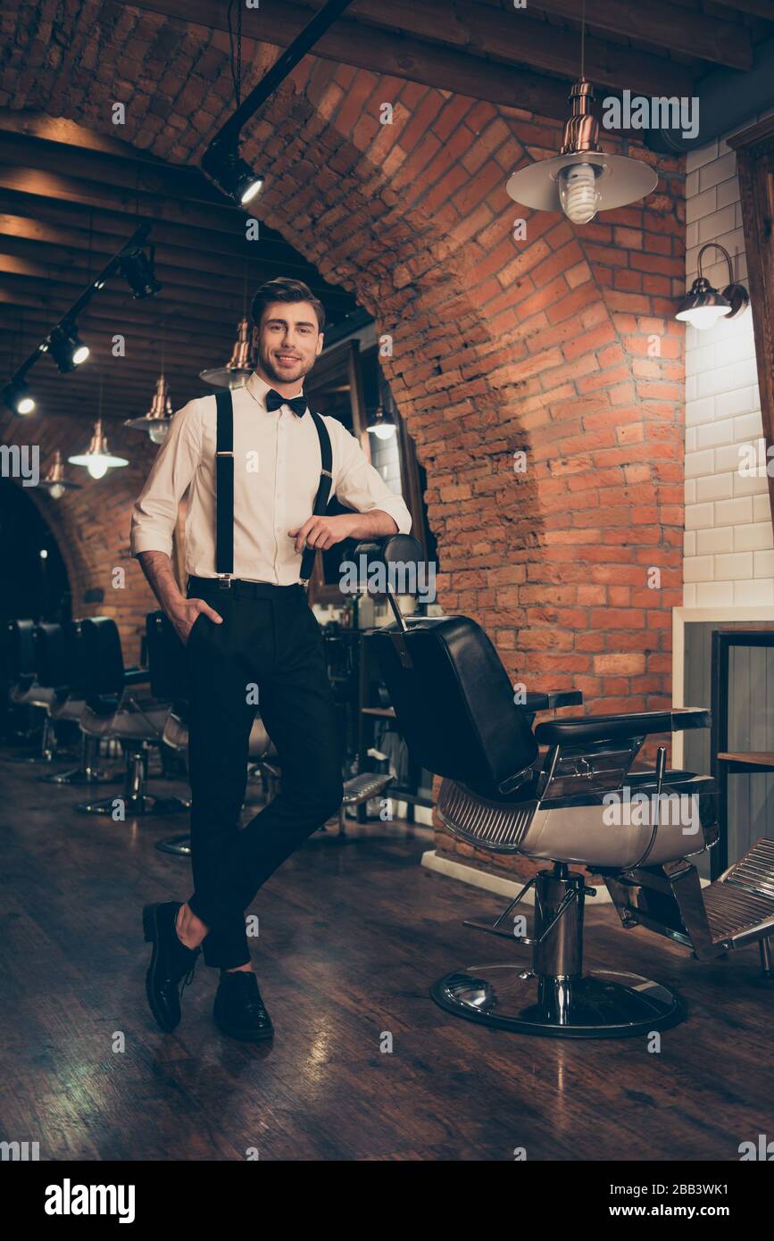 Handsome classy dressed stylist in a barber shop. He is successful and ...