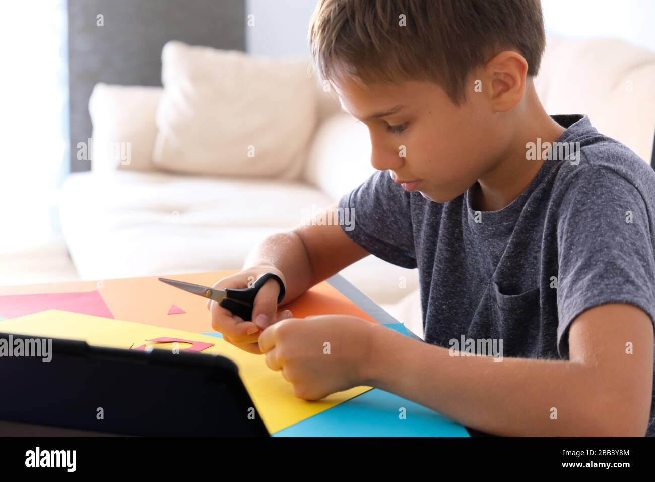 Education, paper crafts for kids. Child cutting colored paper with ...