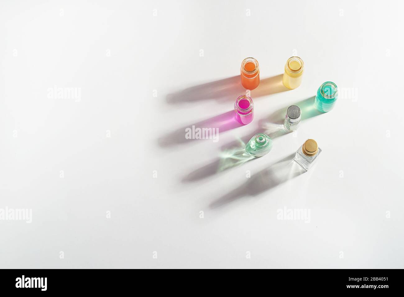 Perfume in a transparent bottle, aromatic oils. Colored shadow on a ...