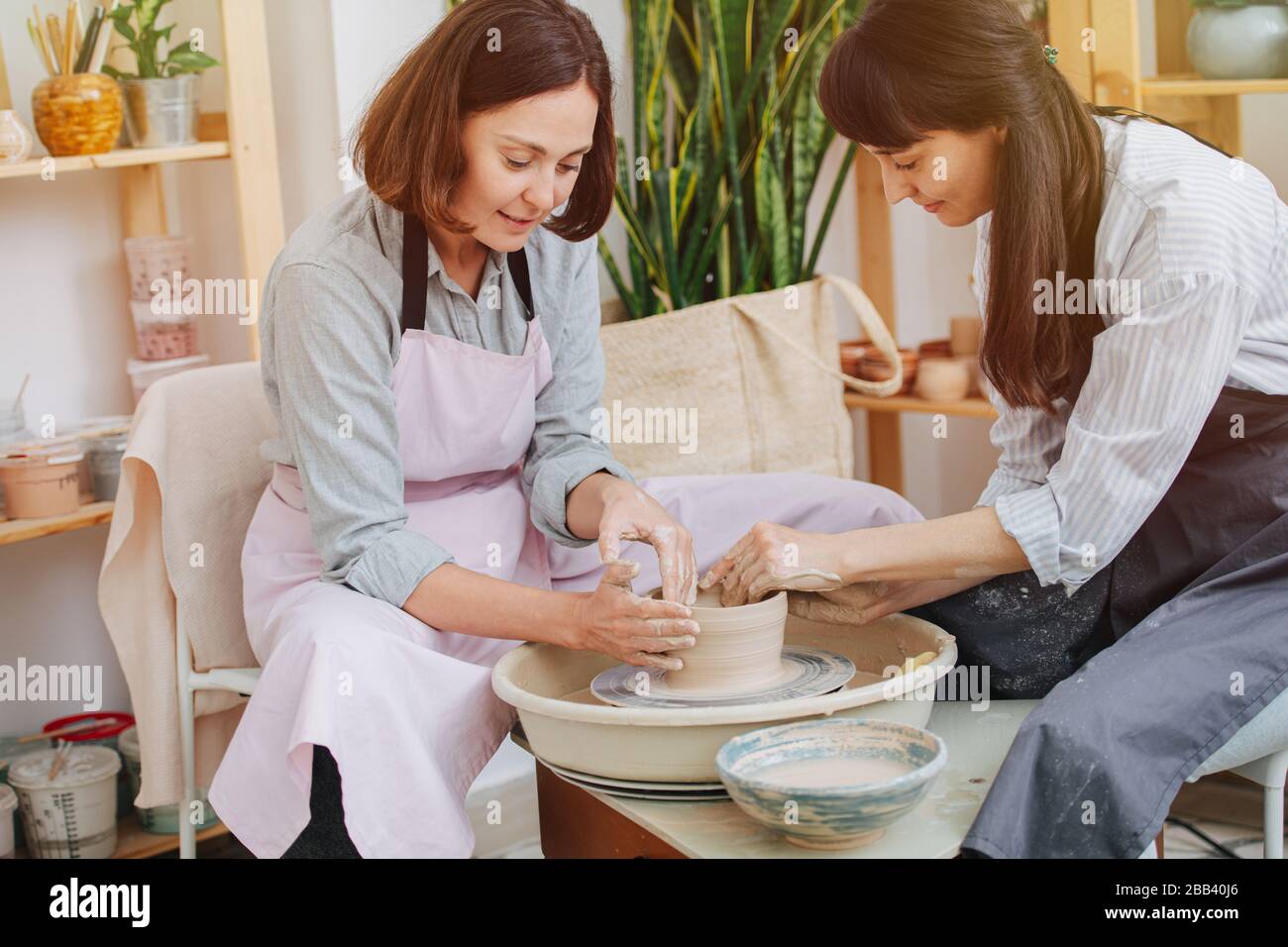 Passing on the experience. Portrait of a pottery master and his student ...