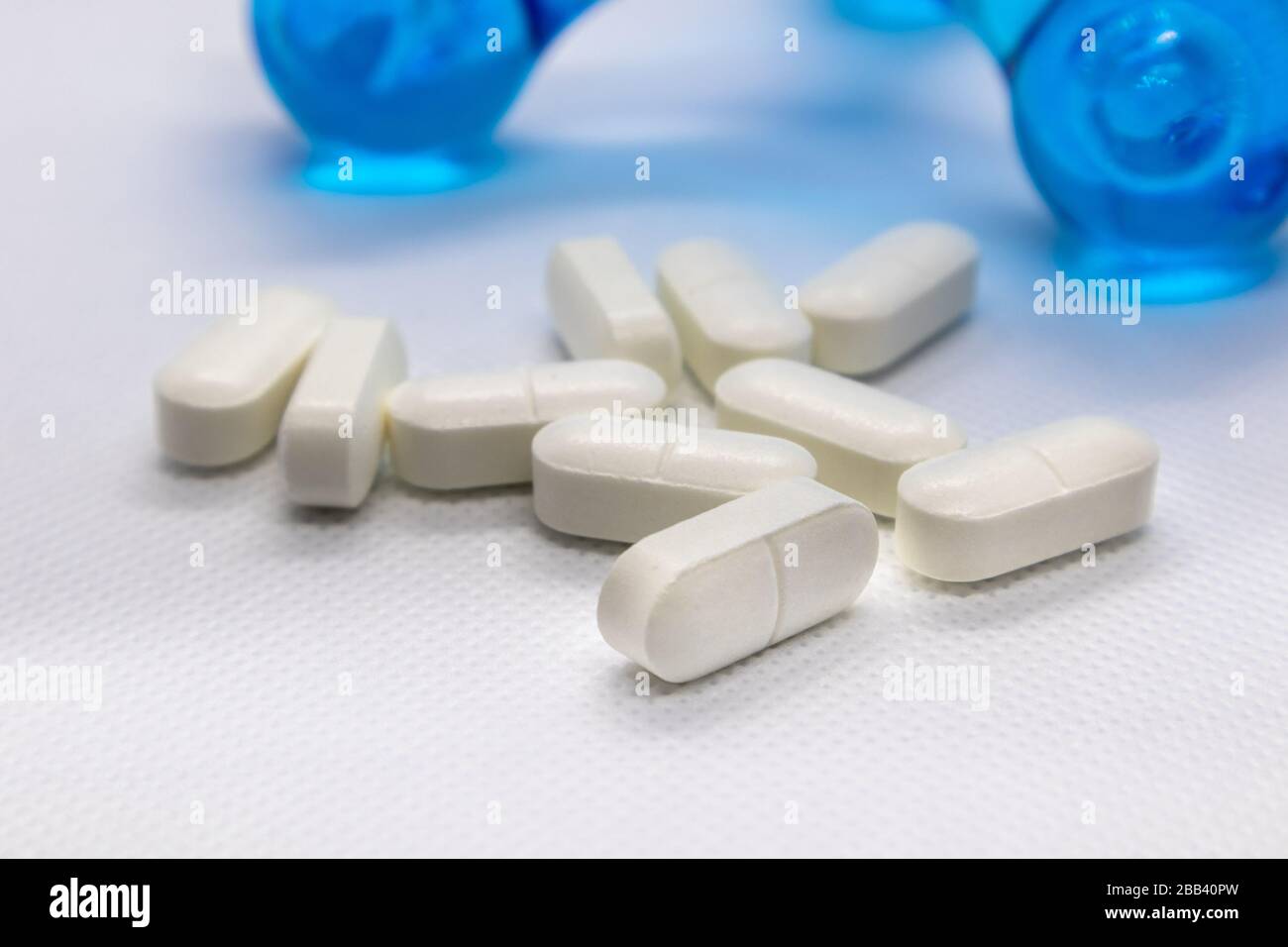 White long pills on white background. Cure medicine health drug light ...