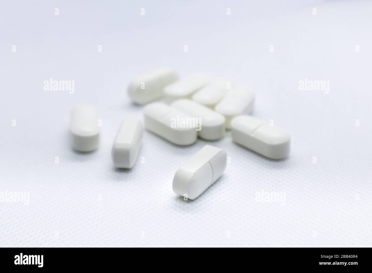 White long pills on white background. Cure medicine health drug light ...