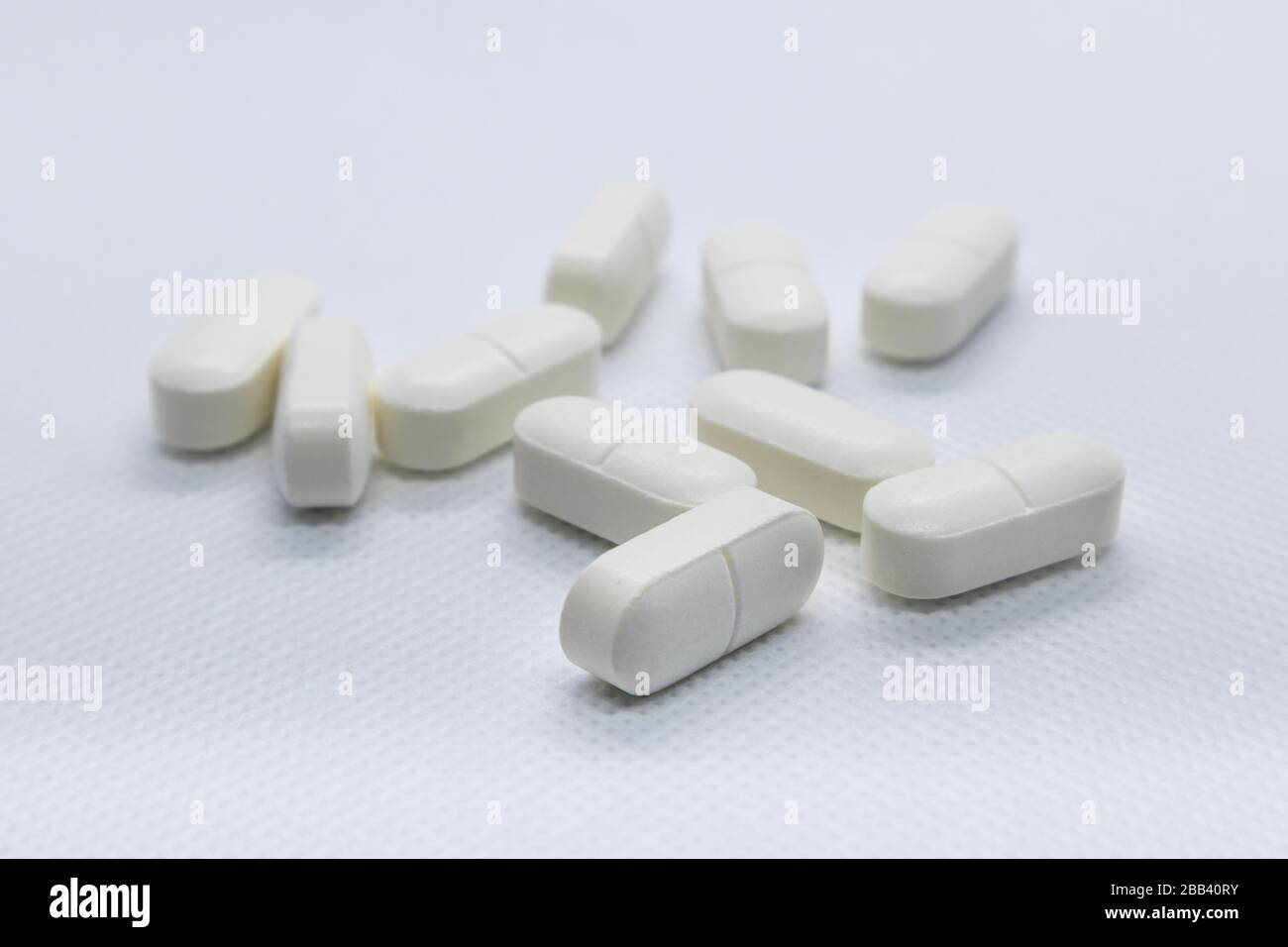 White long pills on white background. Cure medicine health drug light ...