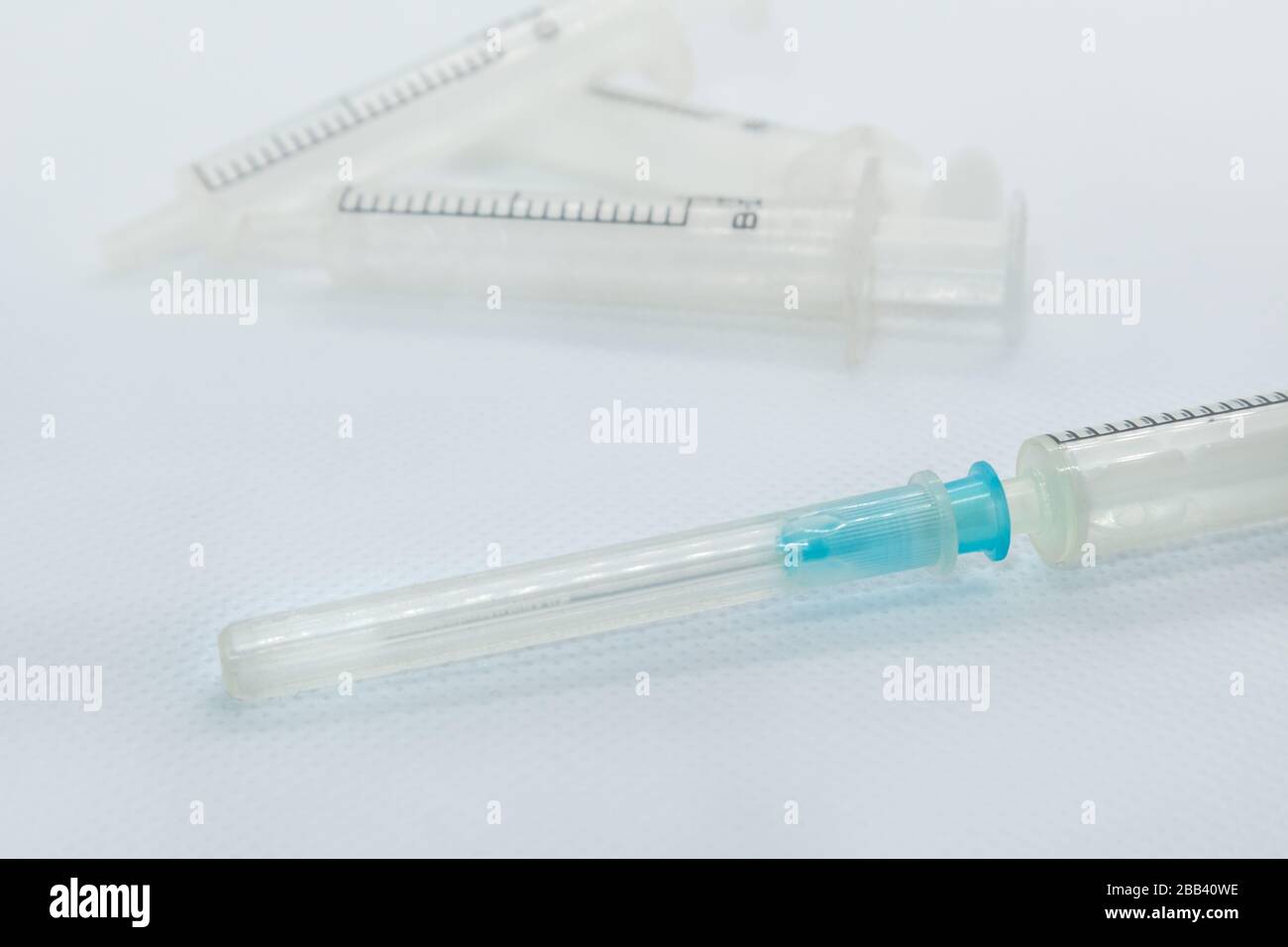 White 2 ml syringes close-up macro on white surface. Medicinal tool for ...