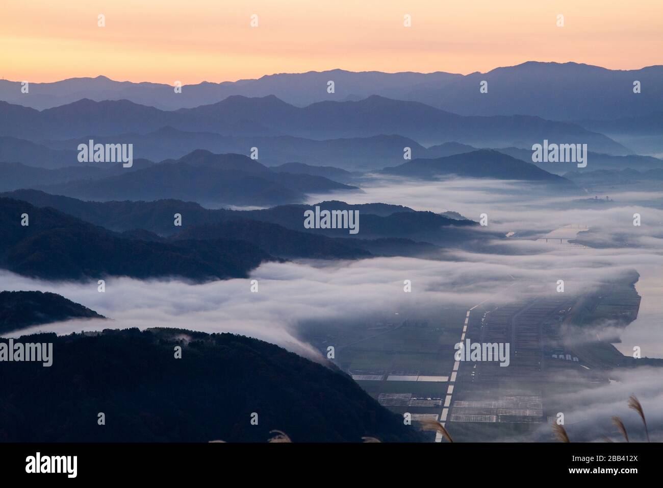 Misty morning sunrise over the bay and city of Toyooka (Toyooka-shi) is ...