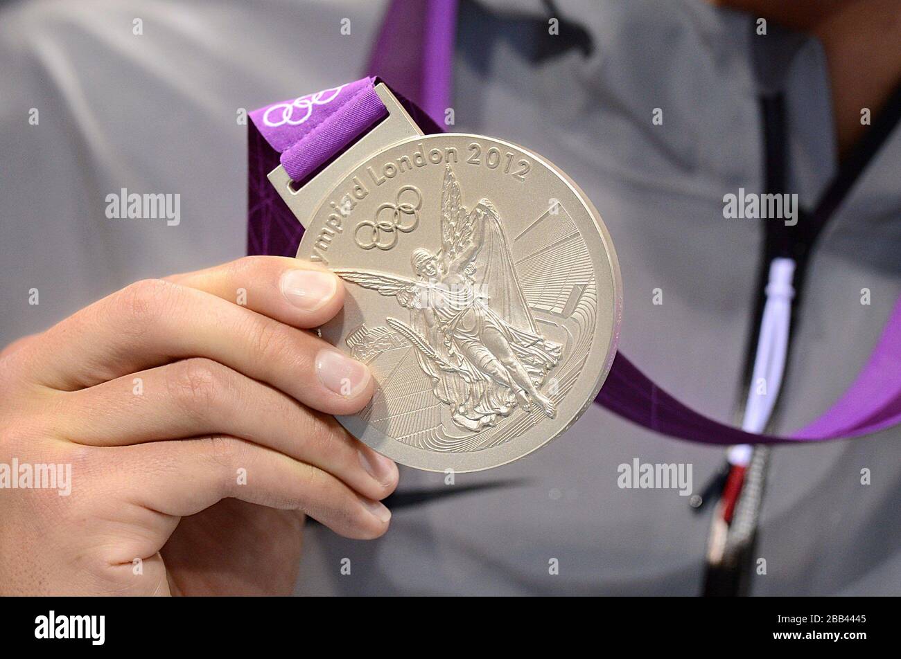 A member of the USA's Men's 4 x 100m Freestyle Relay team holds up a ...