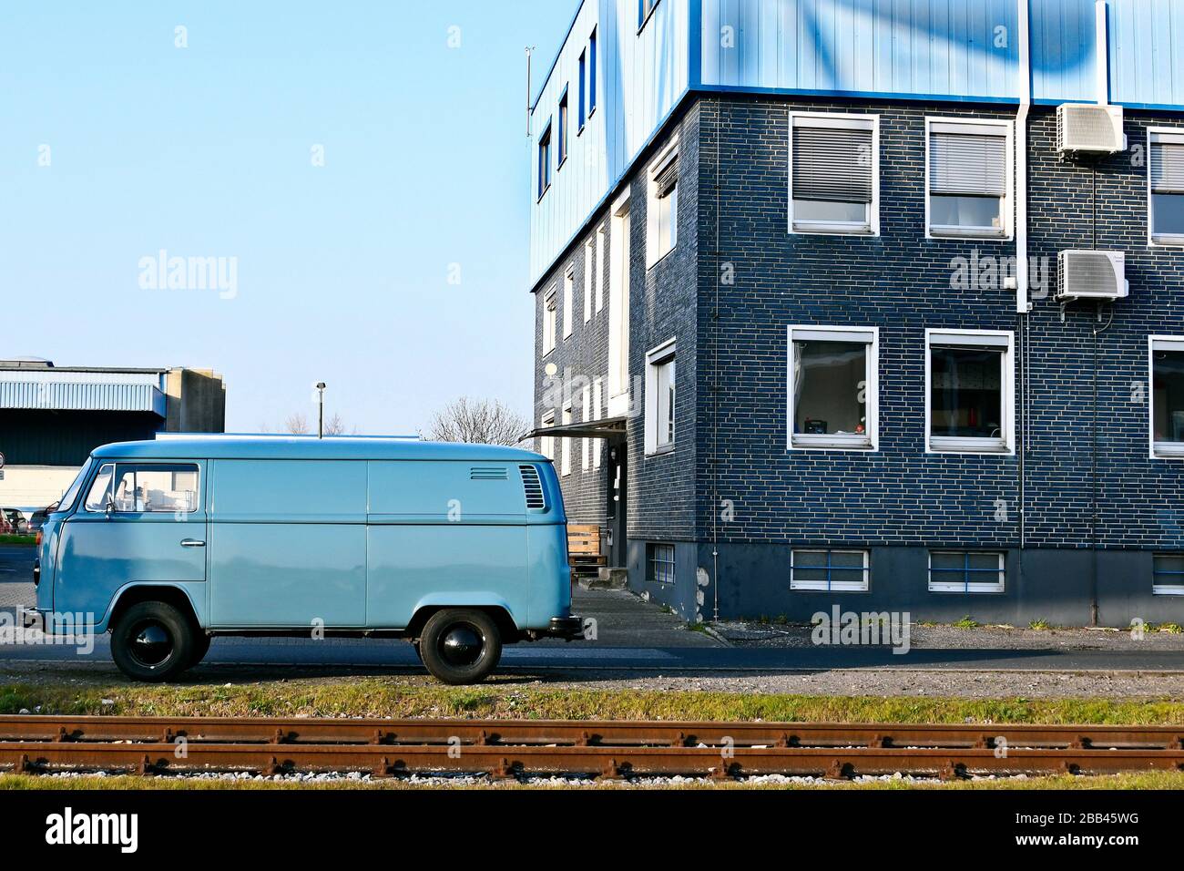 Light blue VW bus next to rails in the shipping port of Düsseldorf ...