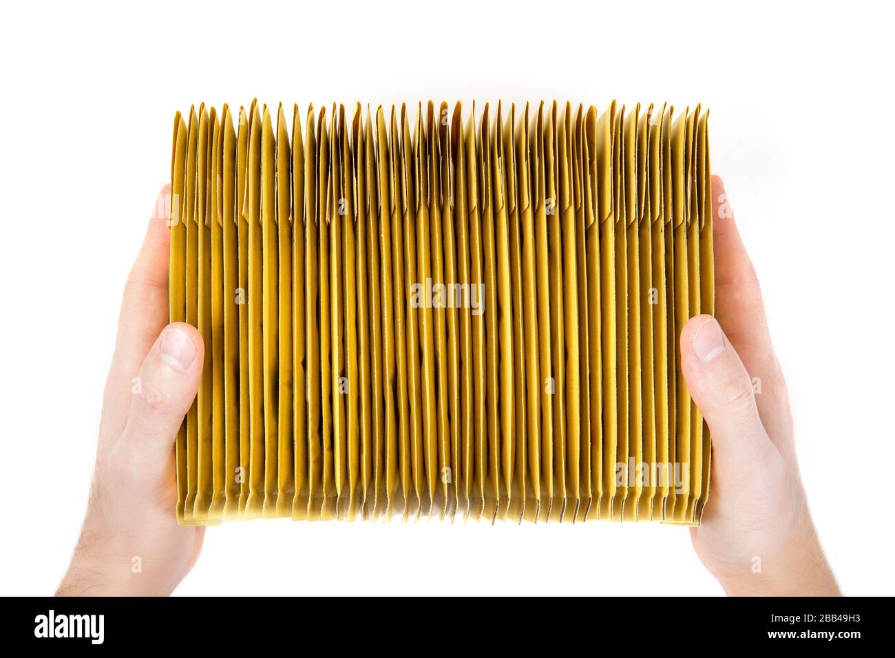 Two male hands holding a stack of yellow shipping envelopes. Top view ...
