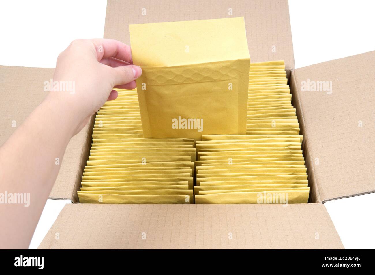 Female hand pulling a shipping envelope out of an opened box full of ...