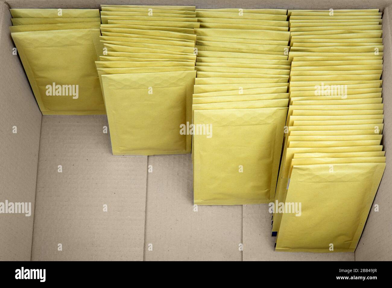 Four ascending rows of bubble envelopes inside a big cardboard box ...
