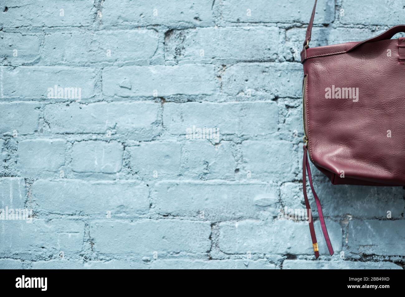Purple leather handbag on blue brick textures Stock Photo - Alamy