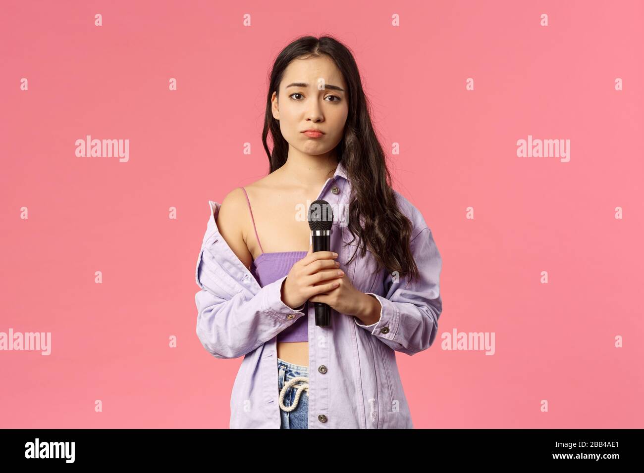 Portrait of gloomy and silly cute asian girl perform sad song in front ...
